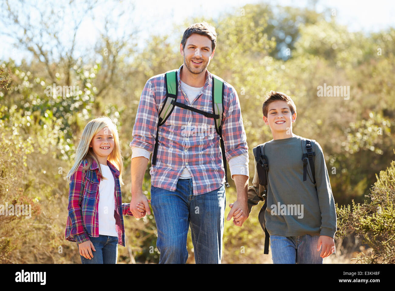 Father And Children Hiking In Countryside Wearing Backpacks Stock Photo ...