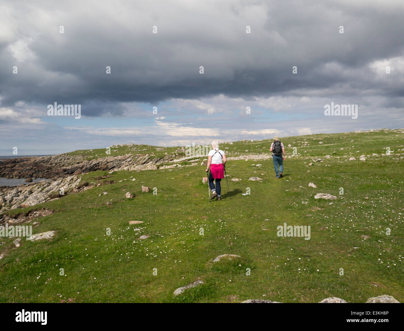 Man and woman walking along coastal footpath of Balnarald RSPB Reserve ...