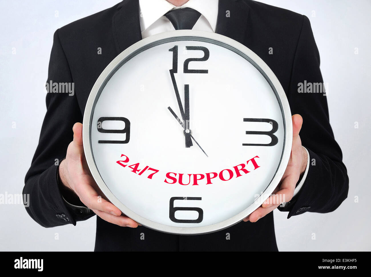 Young business man holding clock Stock Photo - Alamy