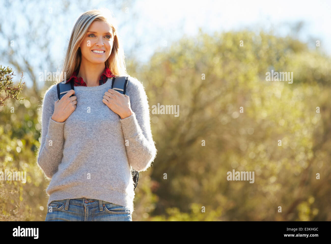 Woman Hiking In Countryside Wearing Backpack Stock Photo - Alamy