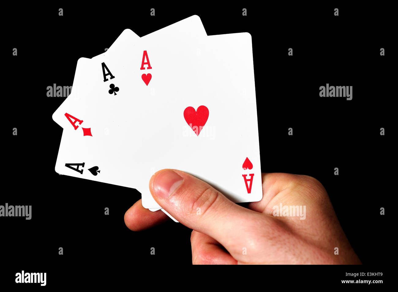 Holding 4 aces on black background Stock Photo - Alamy