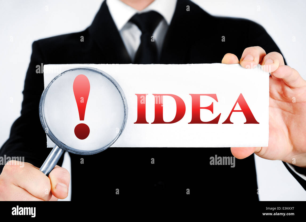 Business man magnifying idea word Stock Photo - Alamy