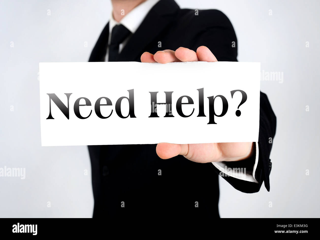 Businessman showing need help on card Stock Photo - Alamy