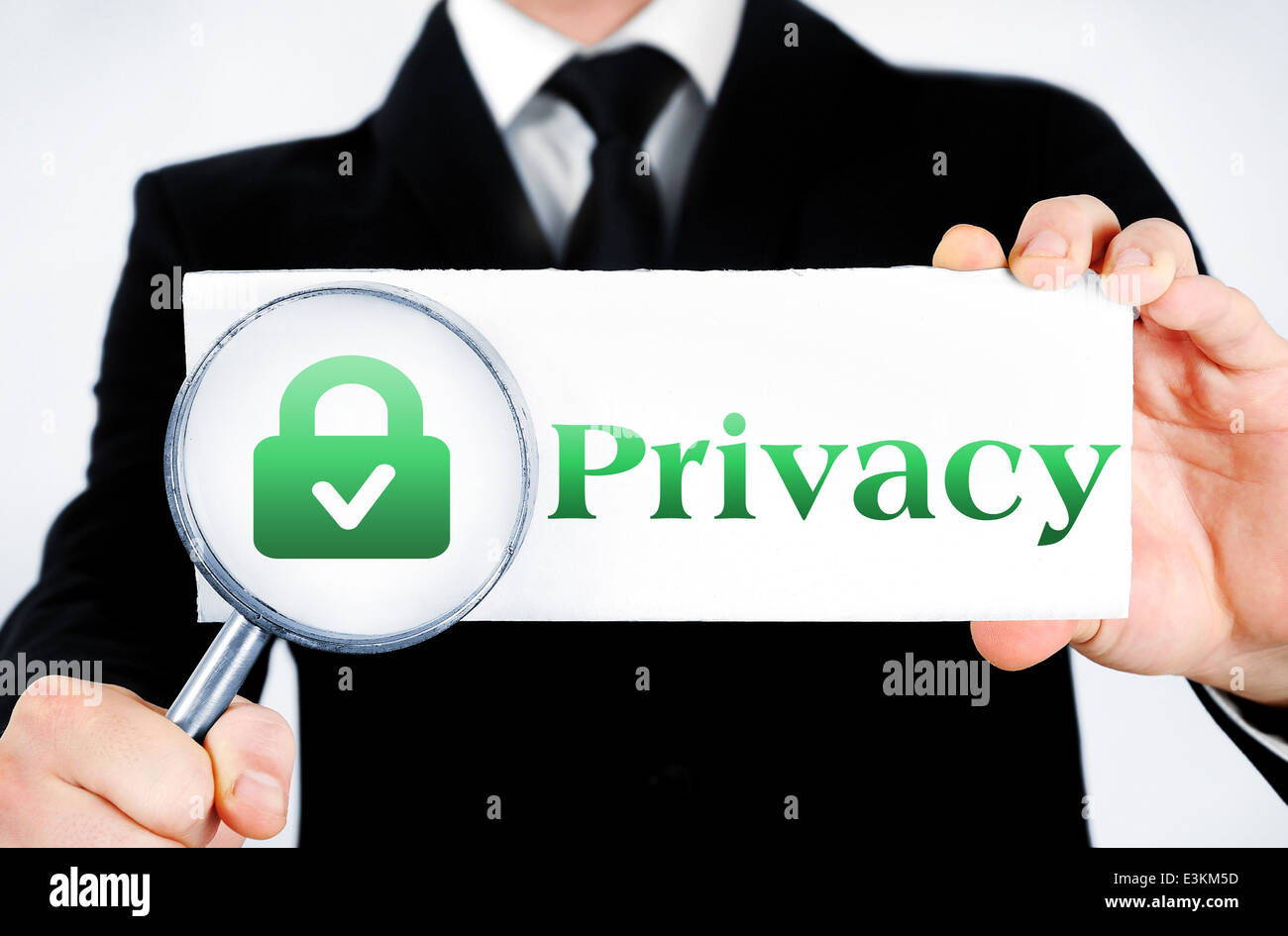 Business man magnifying privacy word Stock Photo - Alamy