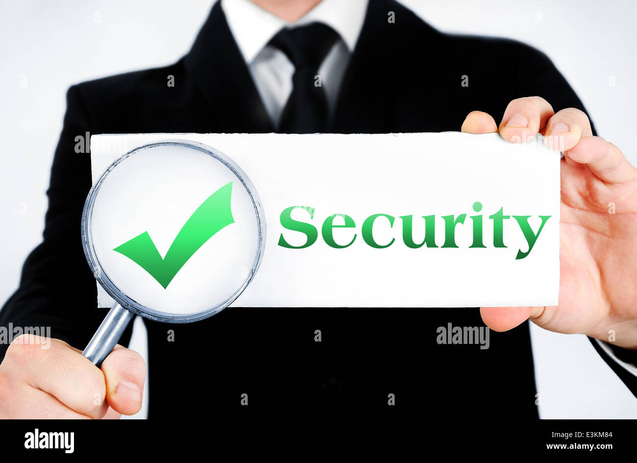 Business man magnifying security word Stock Photo - Alamy