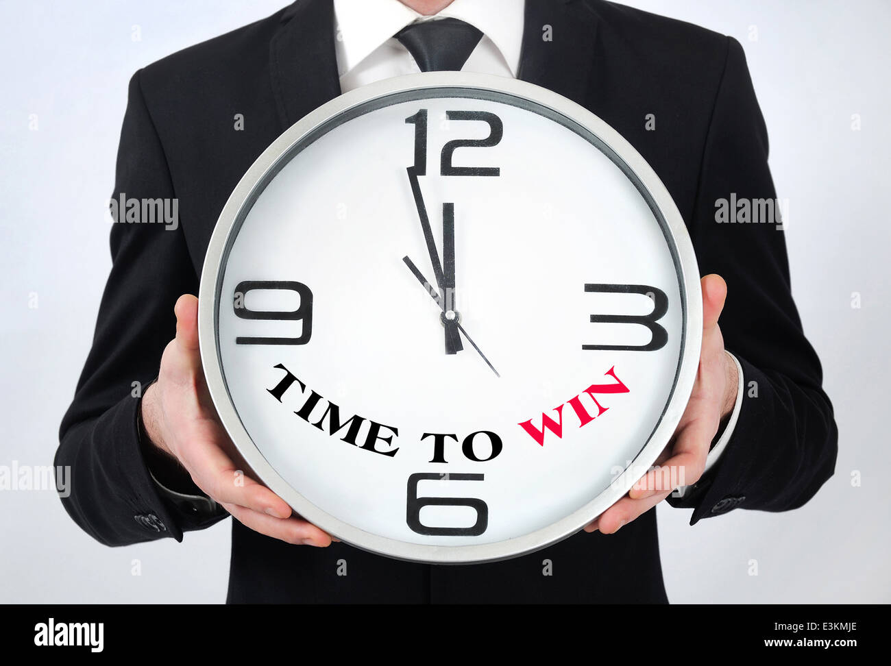 Businessman holding clock with time to win Stock Photo - Alamy