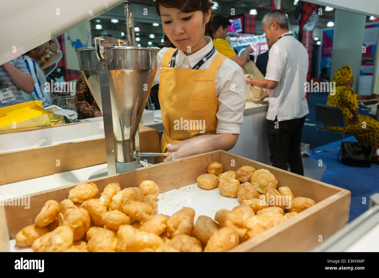 A worker prepares samples of Beard Papa's Fresh and Natural Cream Puffs ...