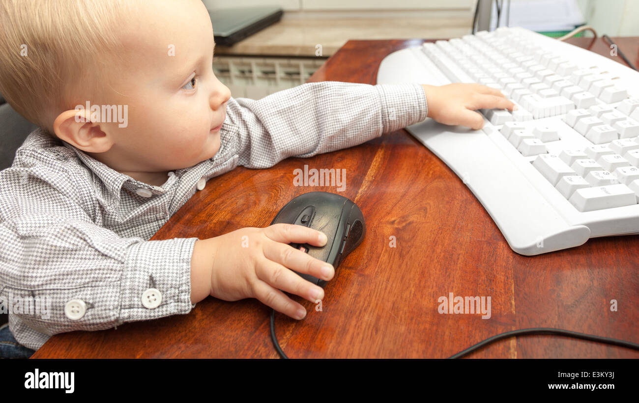 Happy childhood. Smart little boy child kid playing on the desktop ...