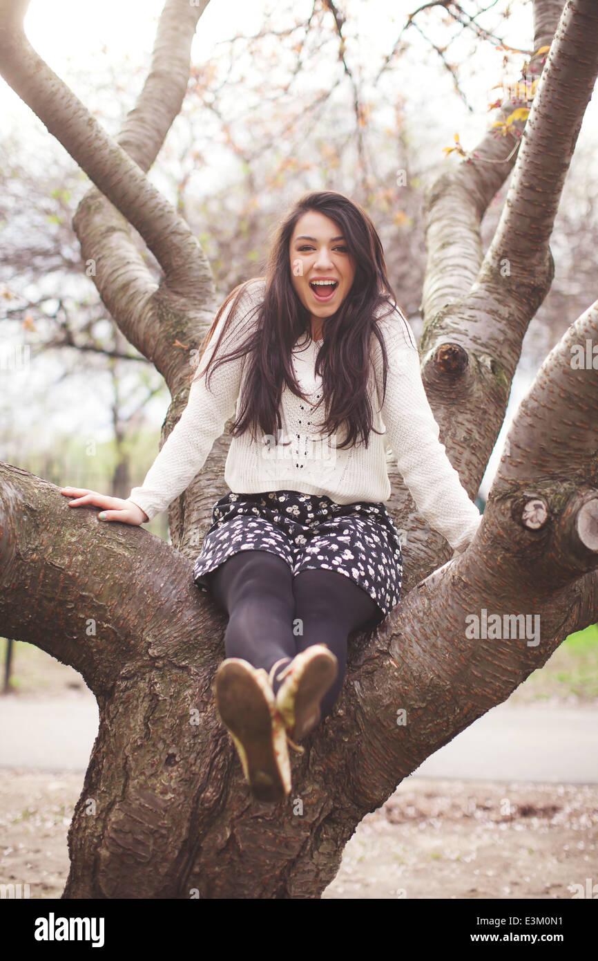 Portrait of young woman sitting on tree trunk, Massachusetts, USA Stock ...
