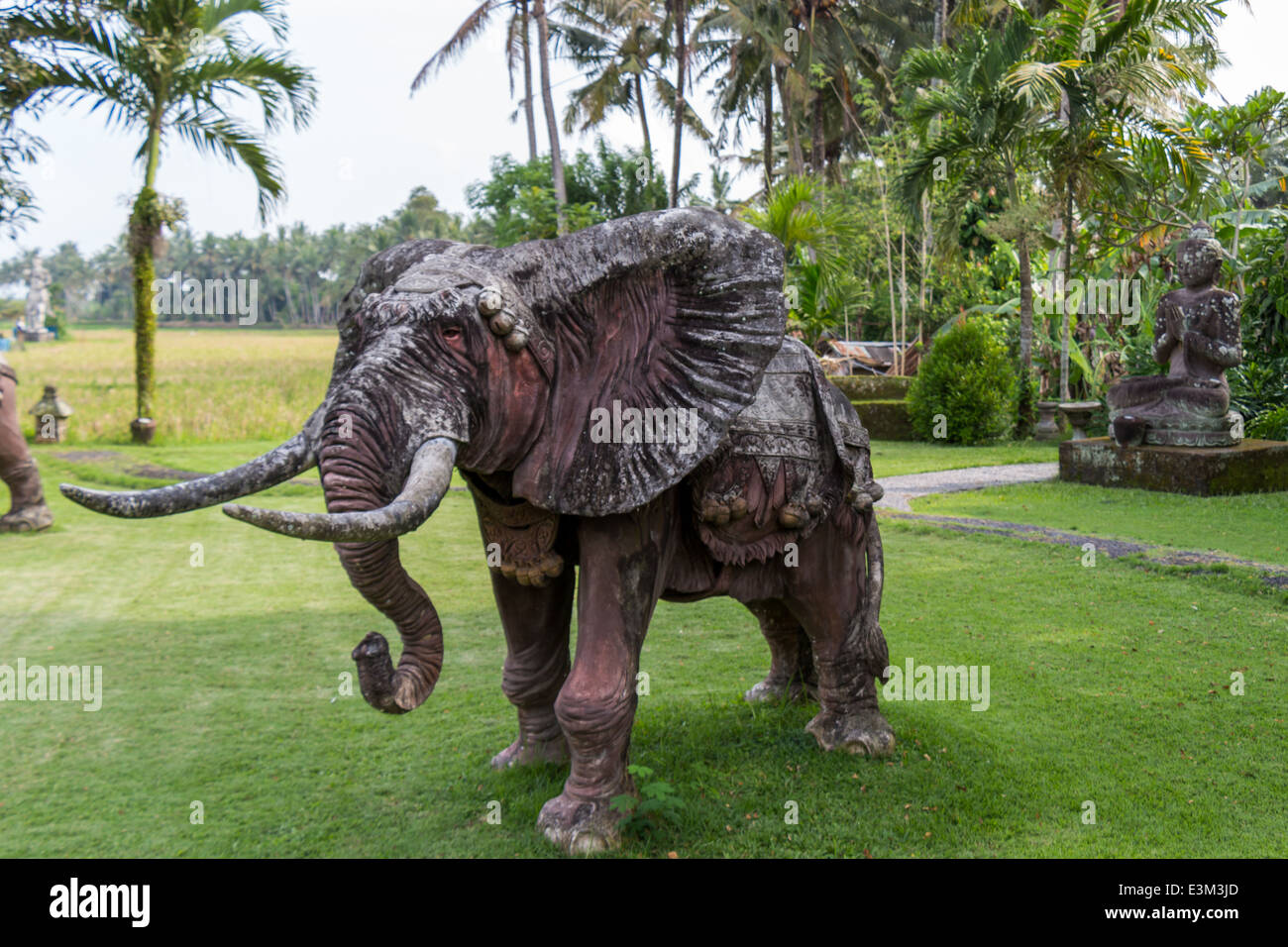Realistic naturalistic elephant statue standing on a lawn at a park or ...
