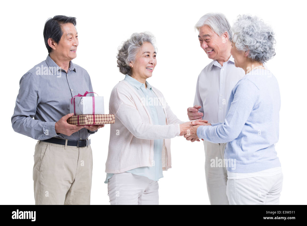 Senior friends gathering and giving gift Stock Photo - Alamy