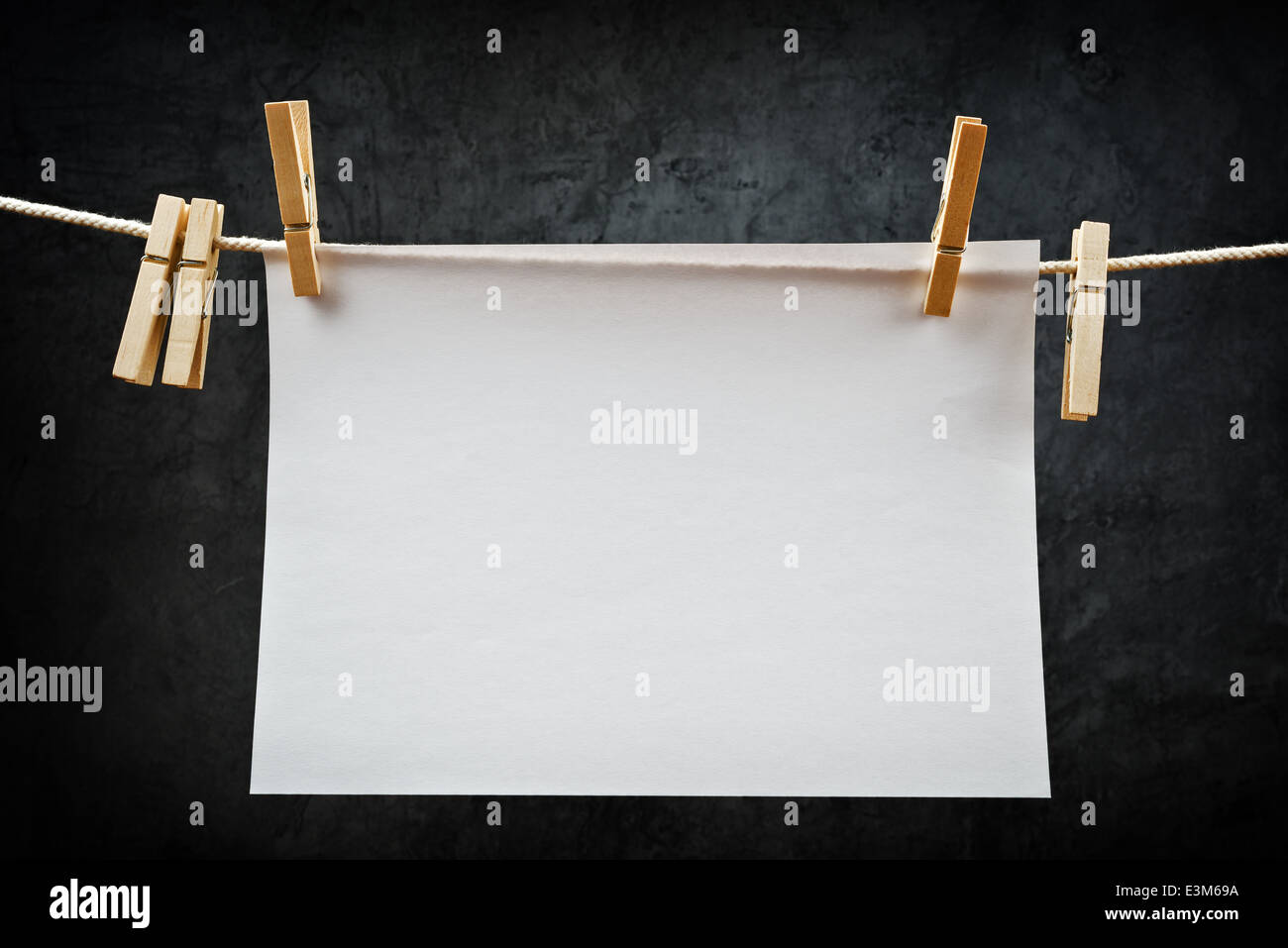 Blank note paper hanging on rope with clothes pins, copy space for your ...