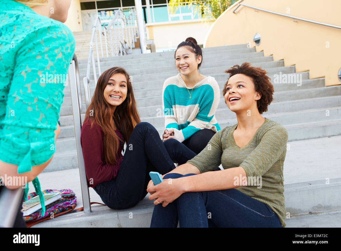 Female High School Students Sitting Outside Building Stock Photo - Alamy