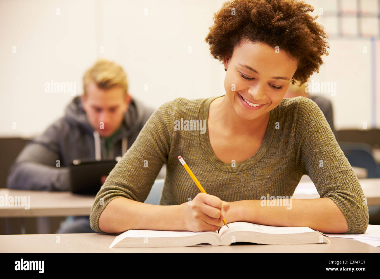 Female High School Student Studying At Desk In Classroom Stock Photo ...