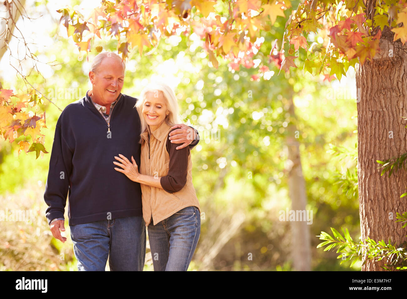 Senior Couple Walking Through Autumn Woodland Stock Photo - Alamy