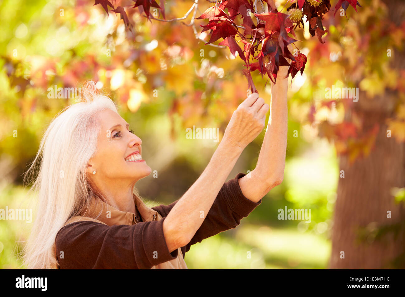 Mature Woman Relaxing In Autumn Landscape Stock Photo - Alamy