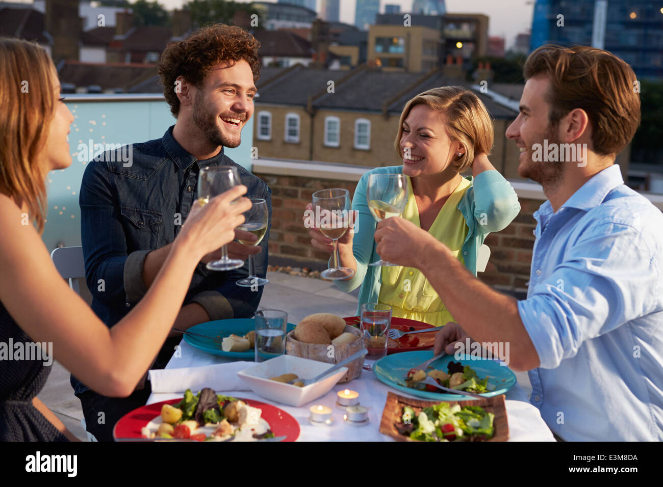 Group Of Friends Eating Meal On Rooftop Terrace Stock Photo - Alamy