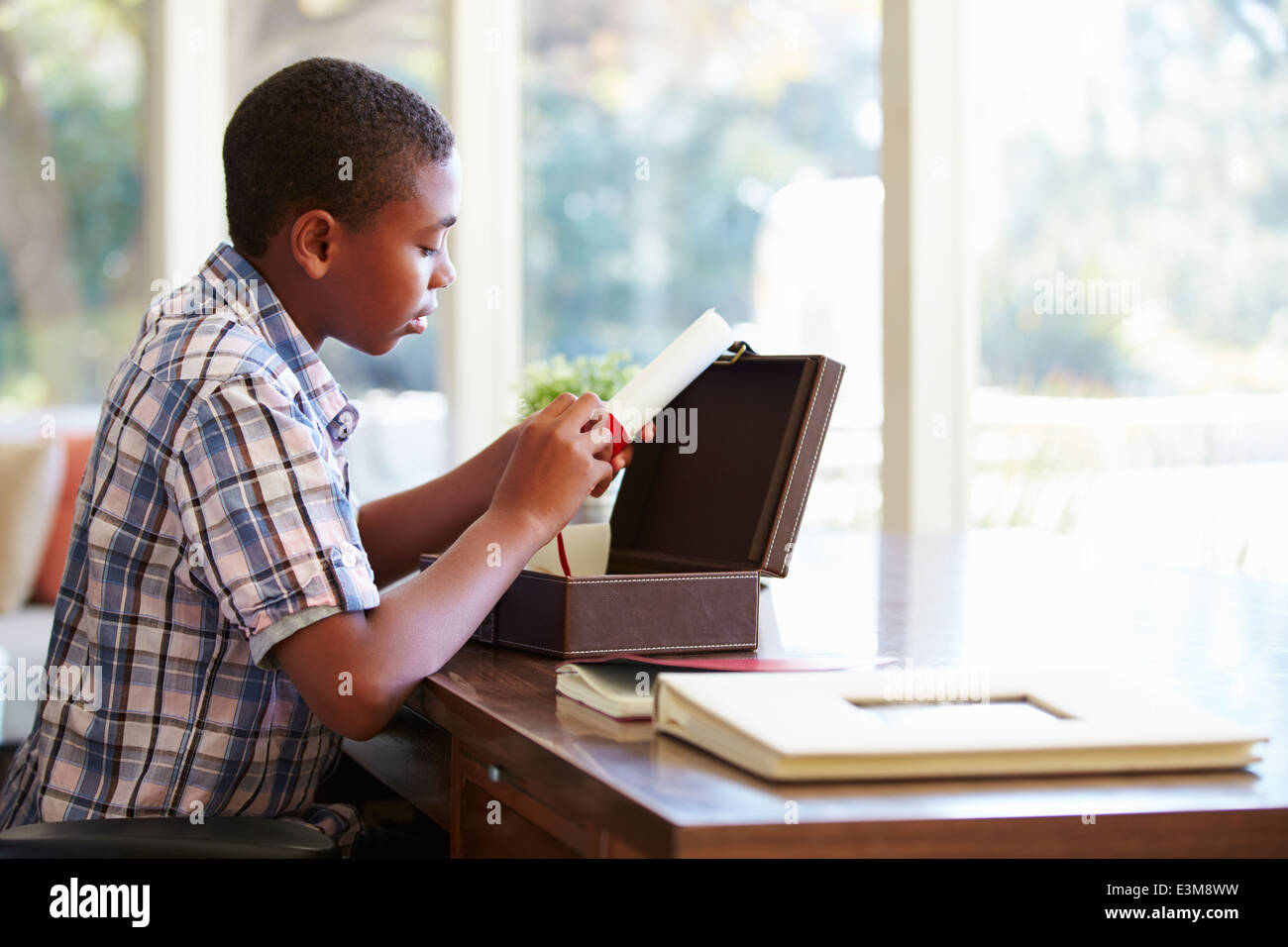 Boy Looking At Document In Keepsake Box On Desk Stock Photo - Alamy