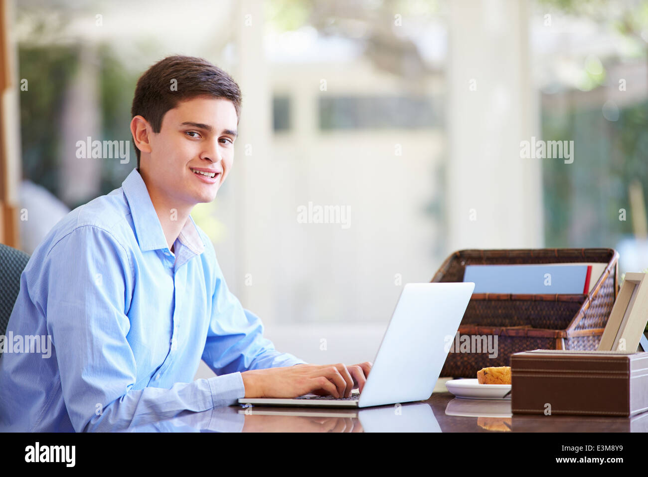 Teenage Boy Using Laptop On Desk At Home Stock Photo - Alamy