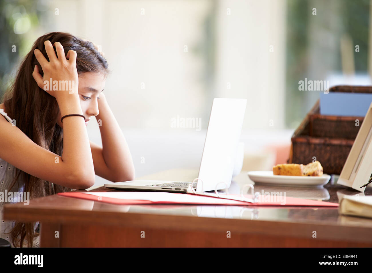 Stressed Teenage Girl Using Laptop On Desk At Home Stock Photo - Alamy