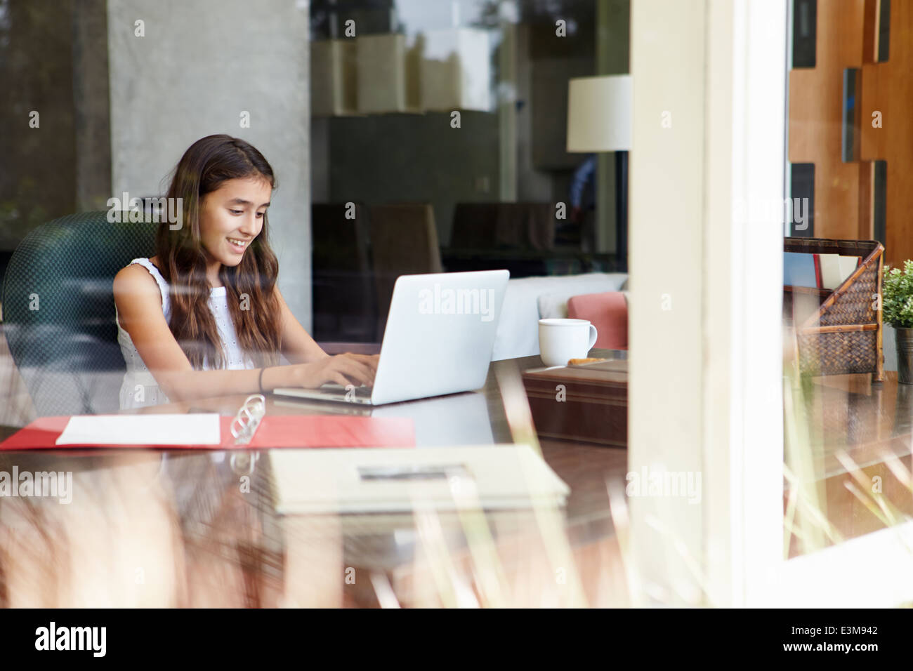 View Of Teenage Girl Using Laptop Through Window Stock Photo - Alamy