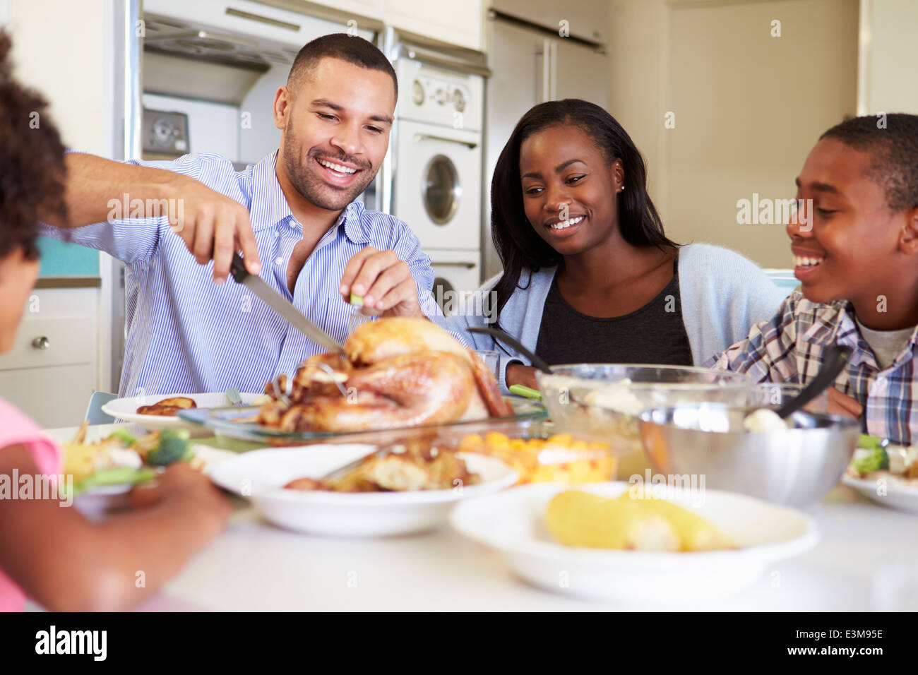 Smiling family around dinner hi-res stock photography and images - Alamy