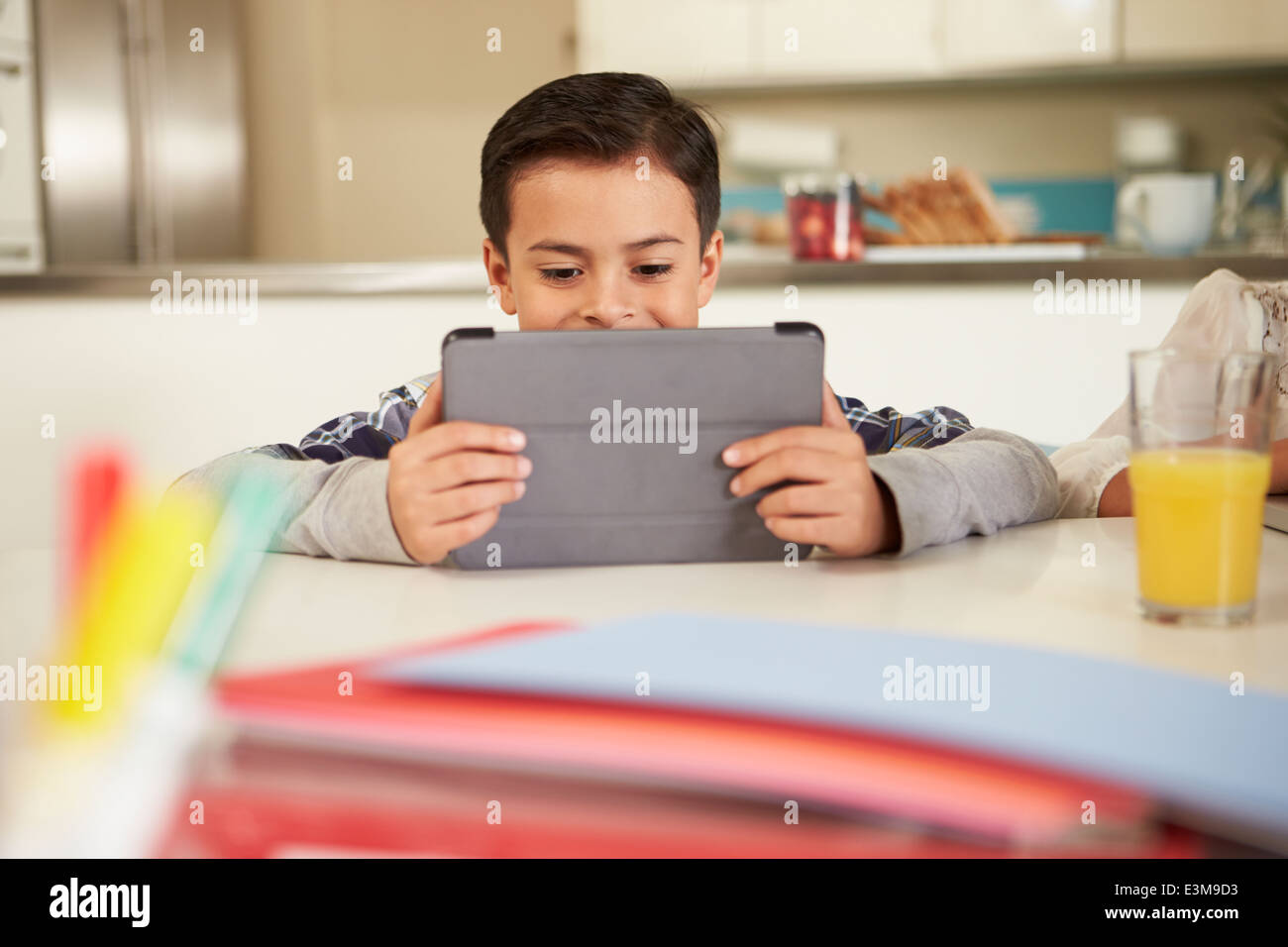 Boy Using Digital Tablet To Do Homework Stock Photo - Alamy