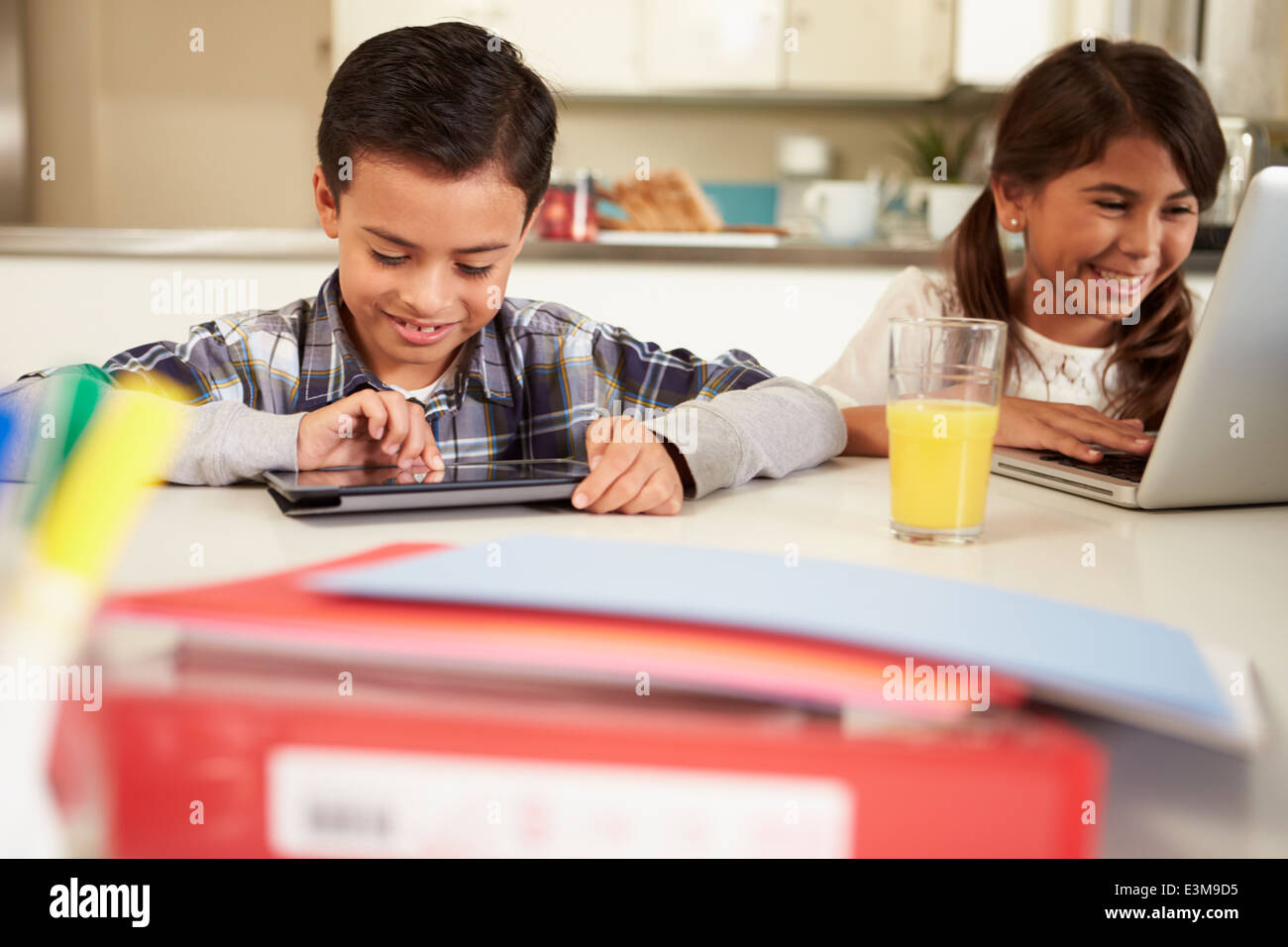 Children Using Laptop And Digital Tablet To Do Homework Stock Photo - Alamy