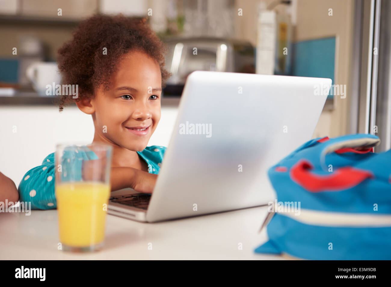 Young Girl Using Laptop To Do Homework At Table Stock Photo - Alamy