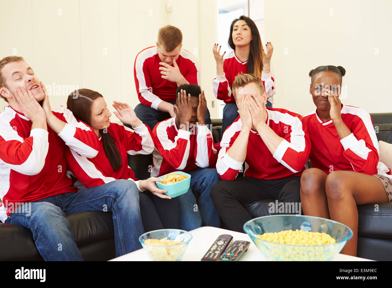 Group Of Sports Fans Watching Game On TV At Home Stock Photo - Alamy