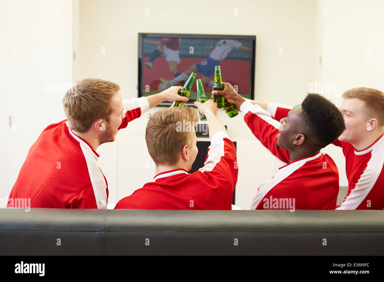 Group Of Sports Fans Watching Game On TV At Home Stock Photo - Alamy