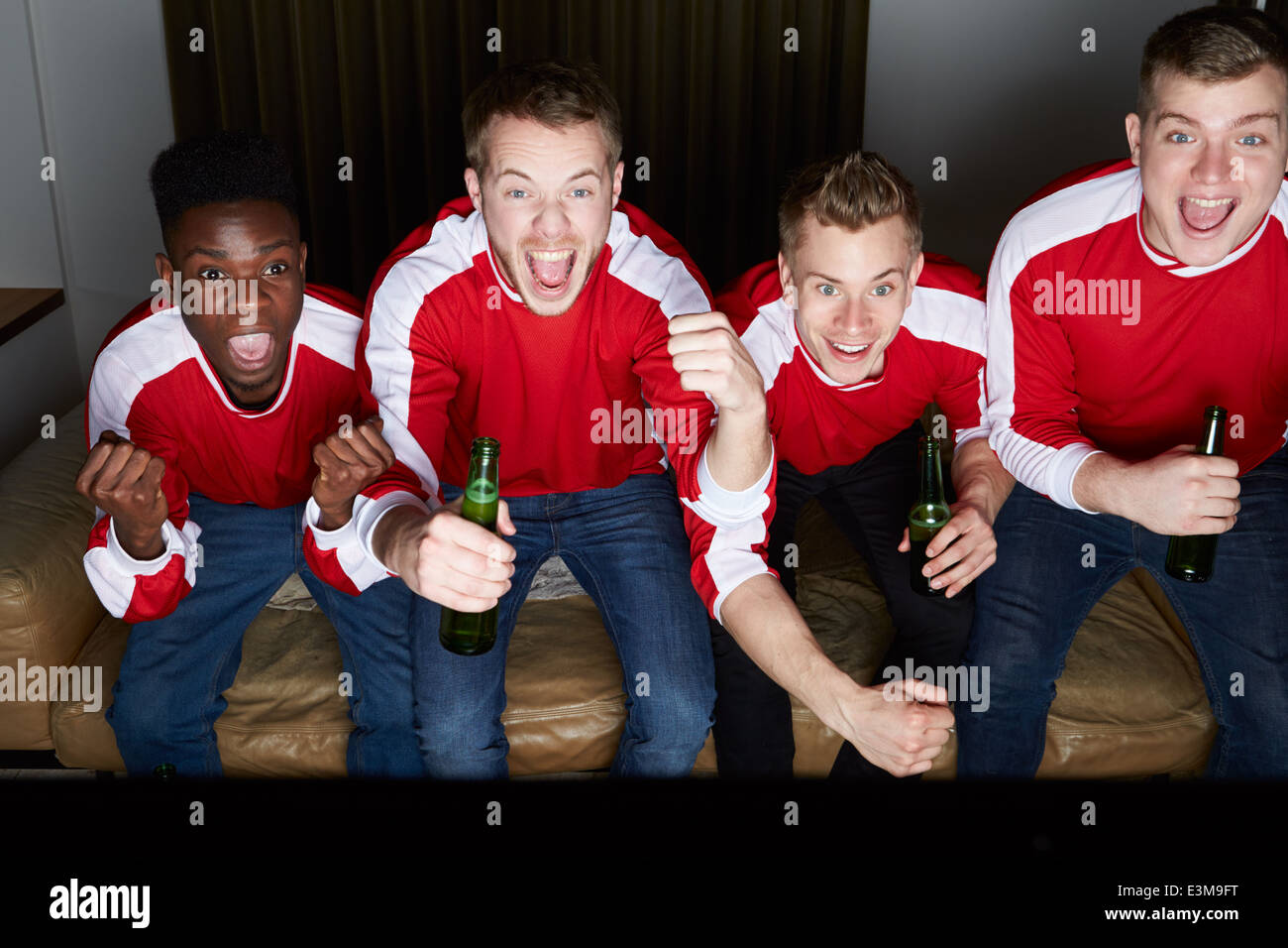 Watching soccer tv cheering night hi-res stock photography and images ...