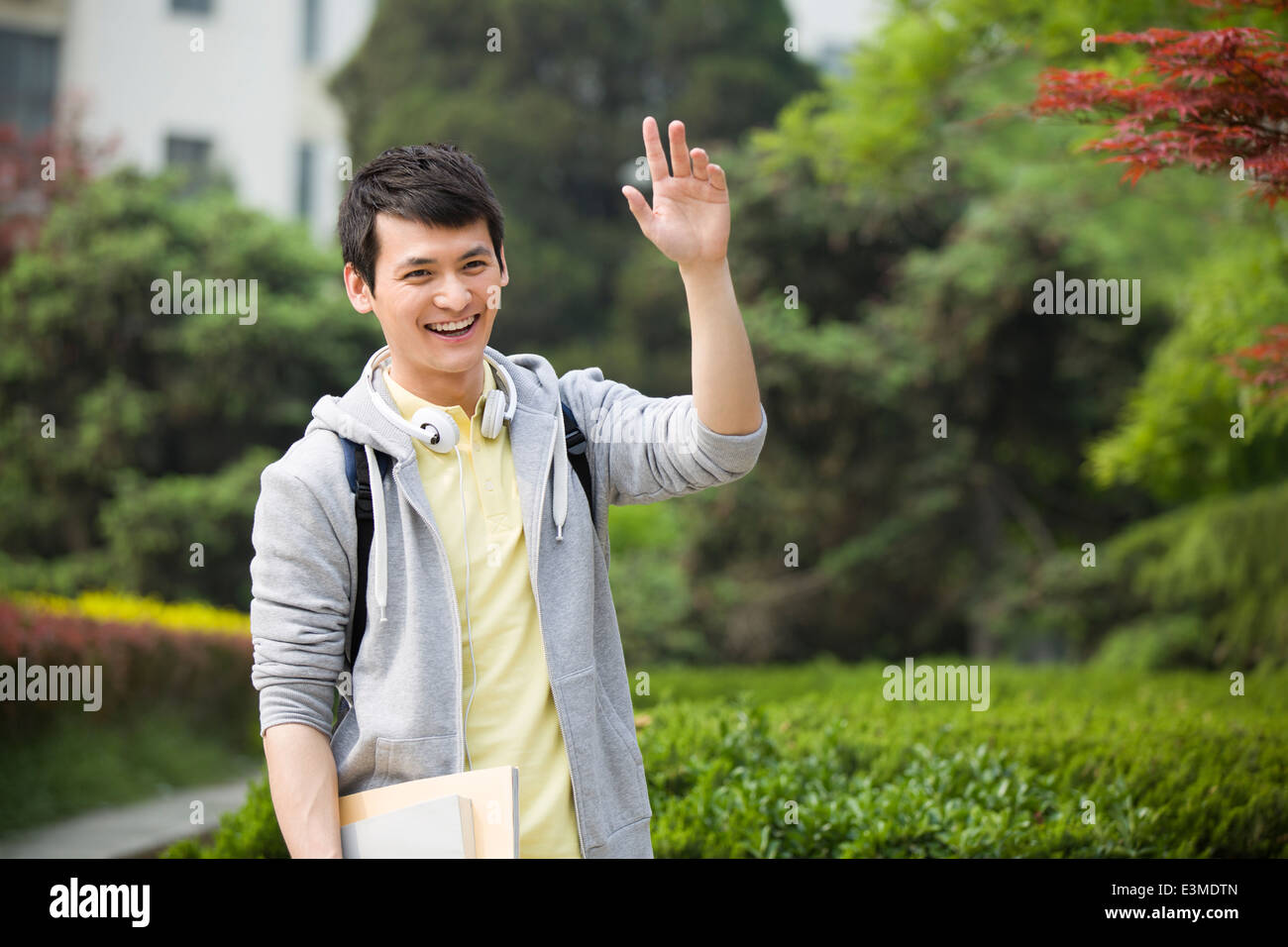 Male college student waving Stock Photo - Alamy