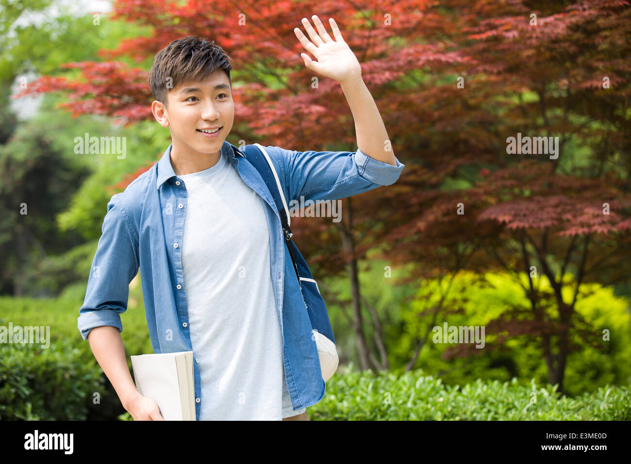 Male college student waving Stock Photo - Alamy