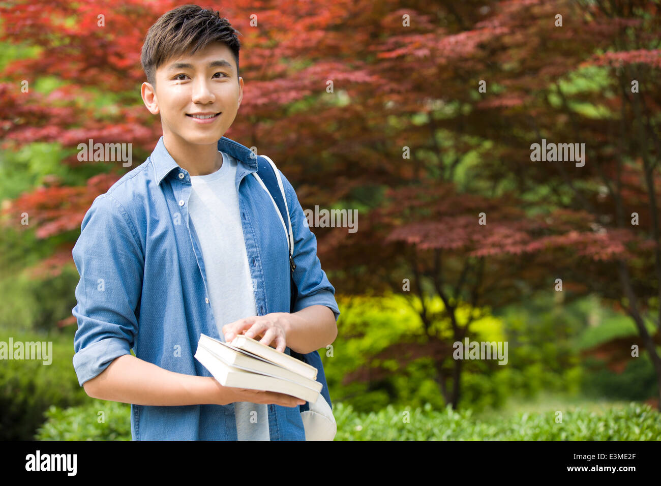 Happy male college student with books Stock Photo - Alamy