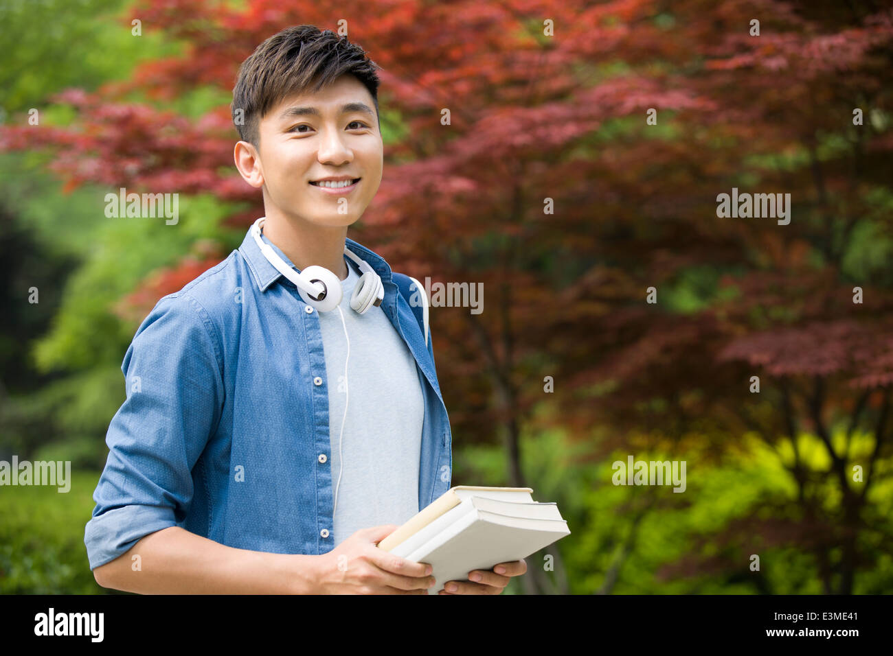 Happy male college student with books Stock Photo - Alamy