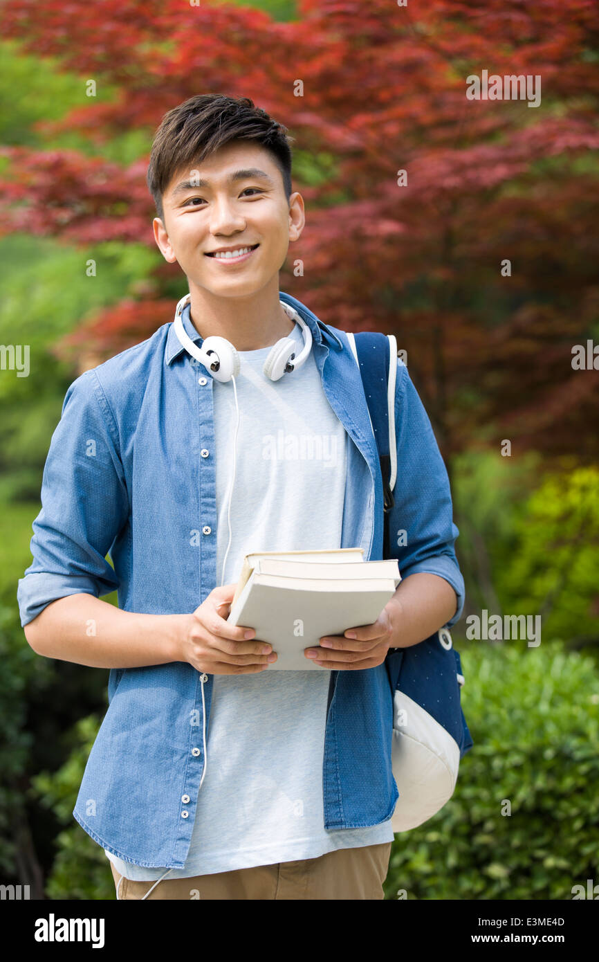 Happy male college student with books Stock Photo - Alamy