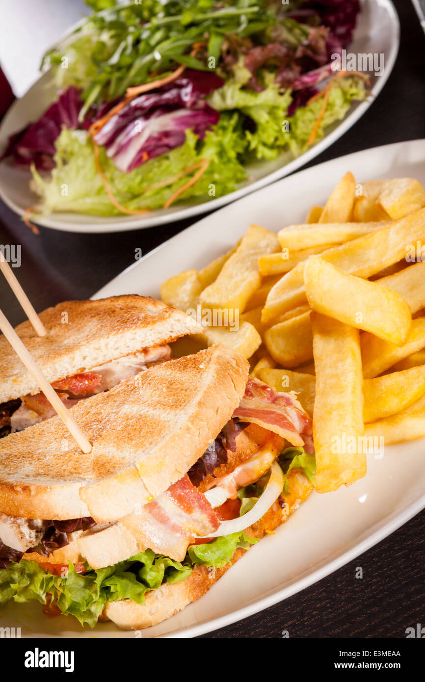 Club sandwich on toasted white bread with a meat filling served with ...