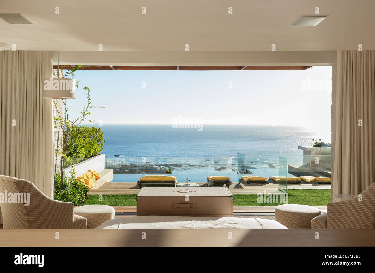 Sunny bedroom and patio overlooking ocean Stock Photo - Alamy