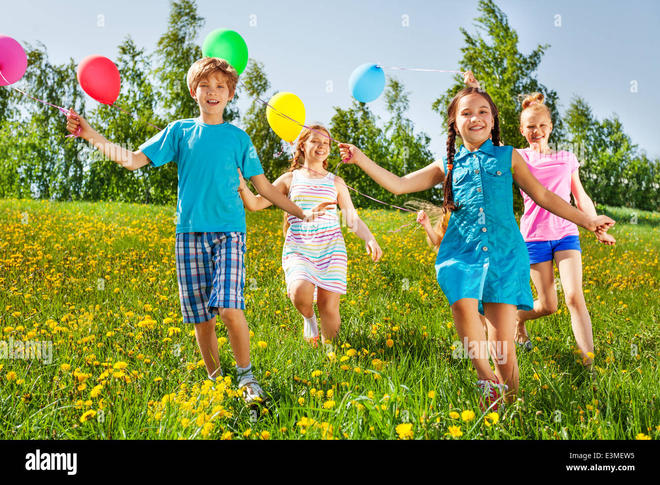 Running happy kids with balloons in green field Stock Photo - Alamy