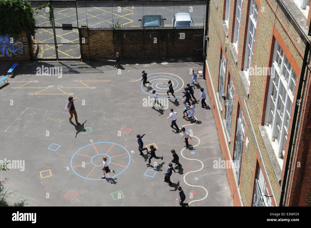 School children playing in a school playground in an inner city london ...