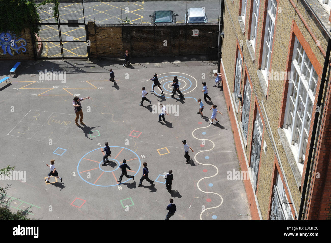 School children playing in a school playground in an inner city london ...
