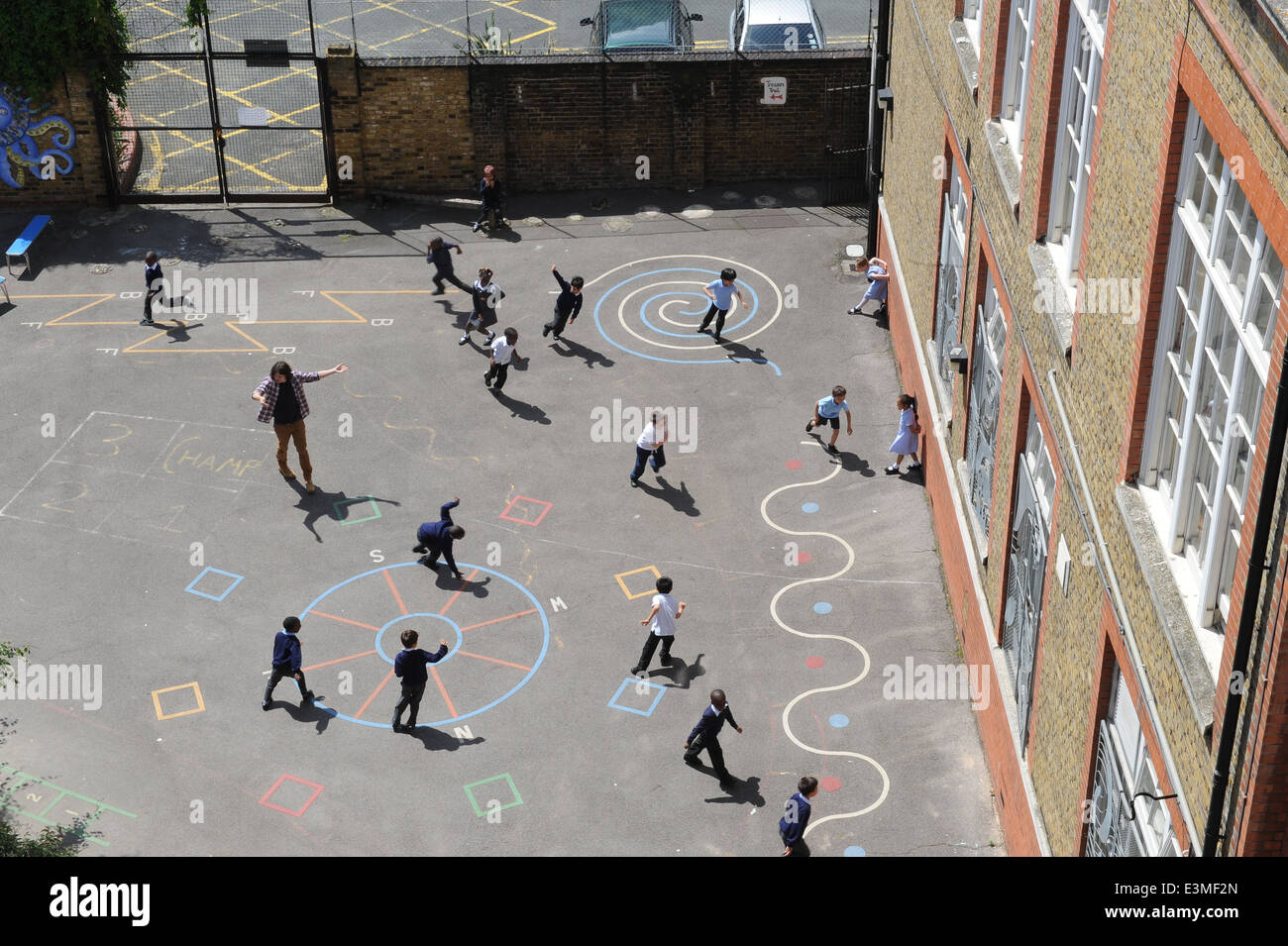 School children playing in a school playground in an inner city london ...