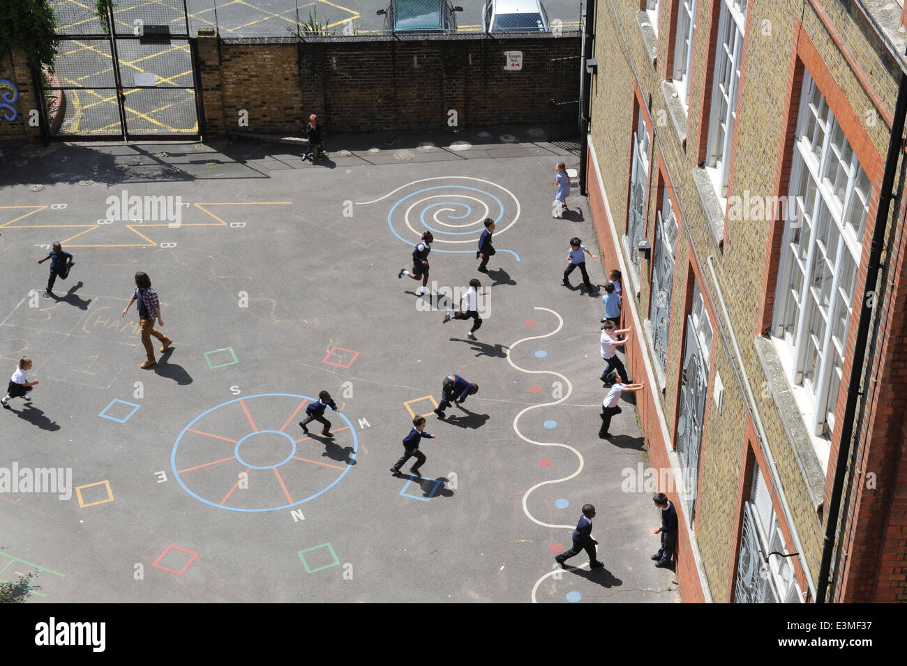 School children playing in a school playground in an inner city london ...