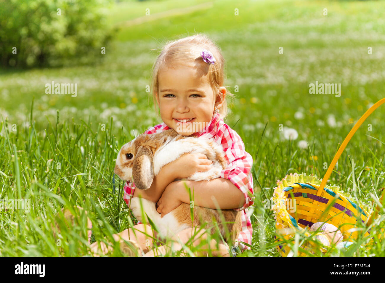 Small girl hugging rabbit in field Stock Photo - Alamy