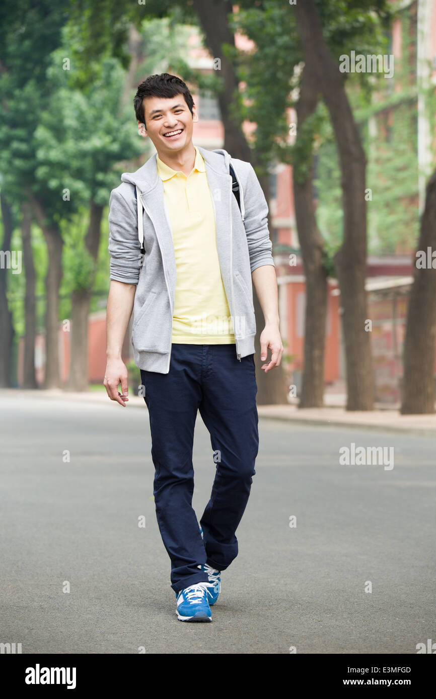 Male college student walking on campus Stock Photo - Alamy