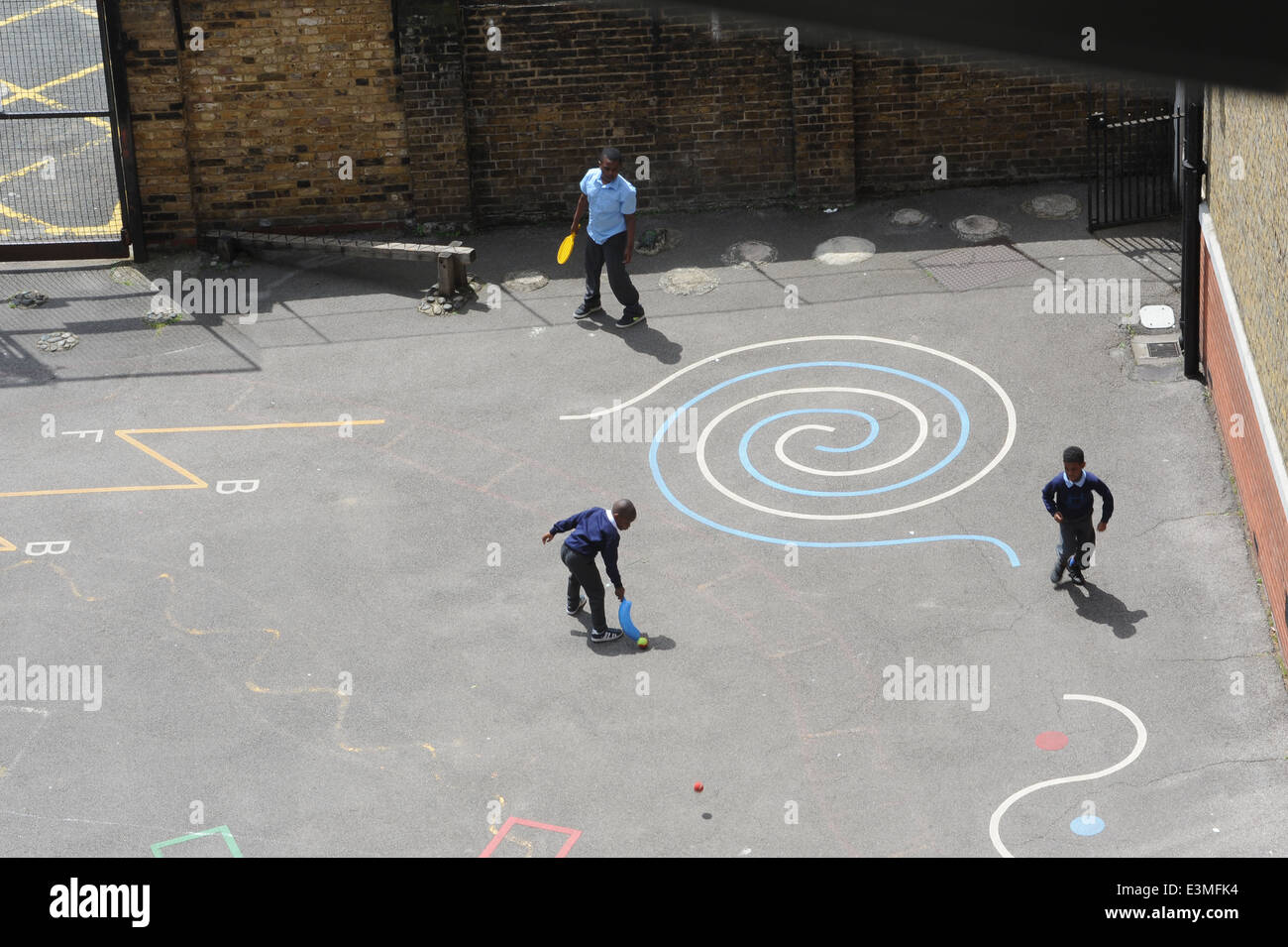 School children playing in a school playground in an inner city london ...