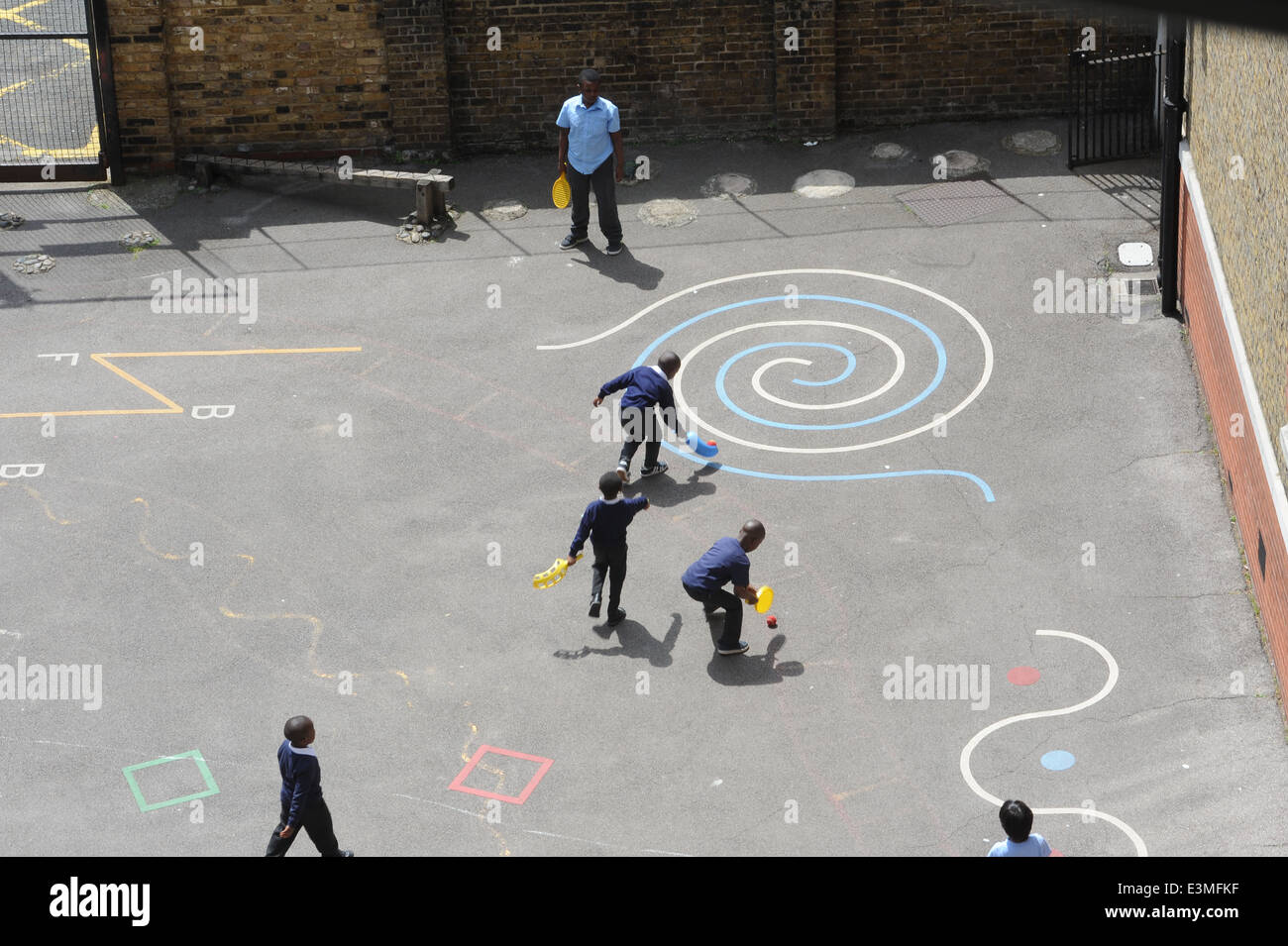 School children playing in a school playground in an inner city london ...