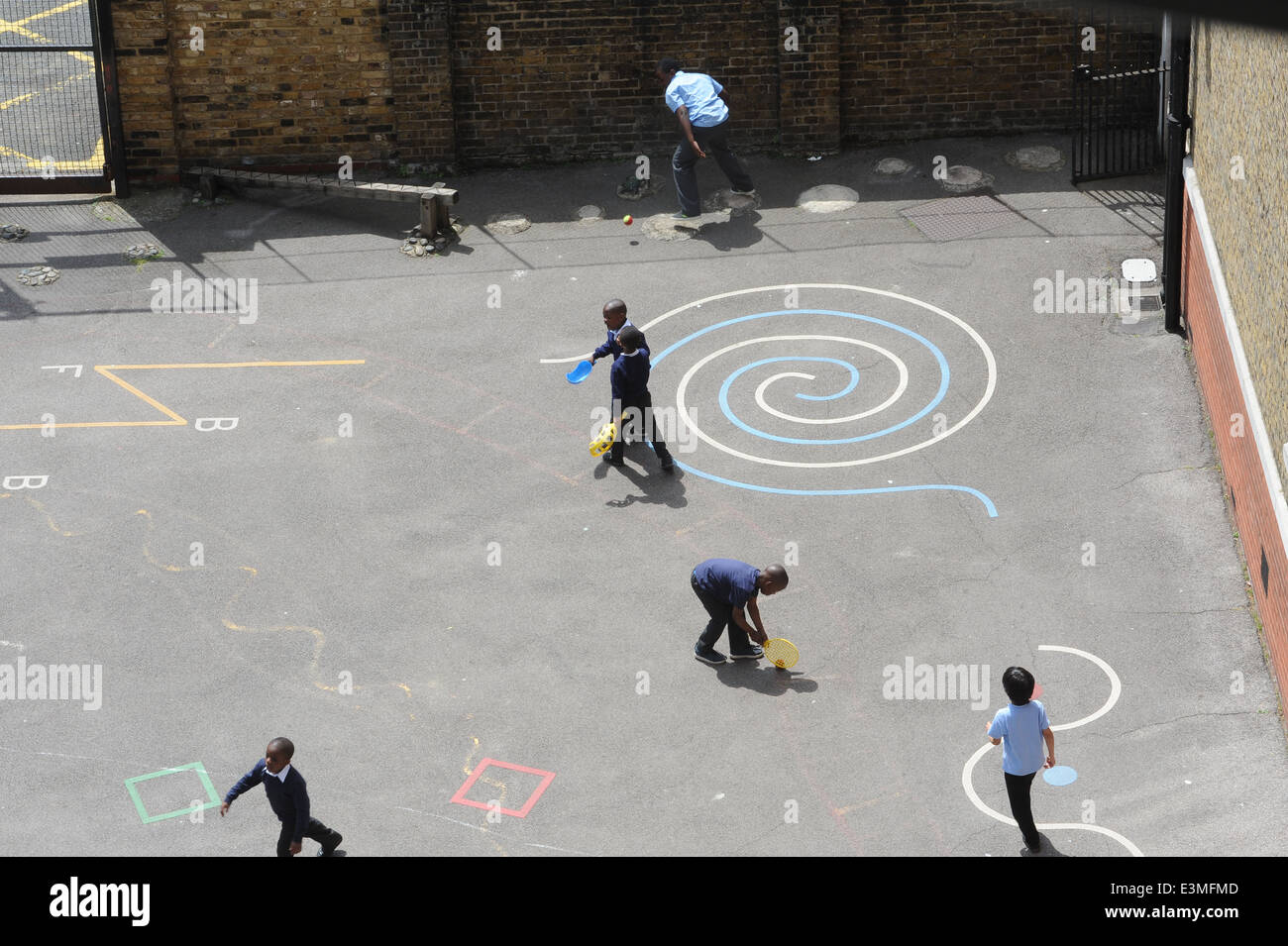 School children playing in a school playground in an inner city london ...