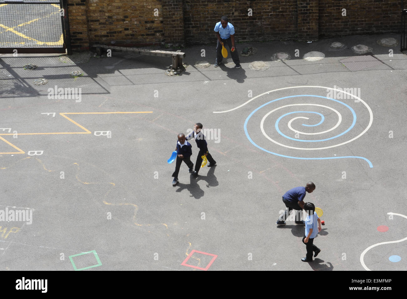 School children playing in a school playground in an inner city london ...
